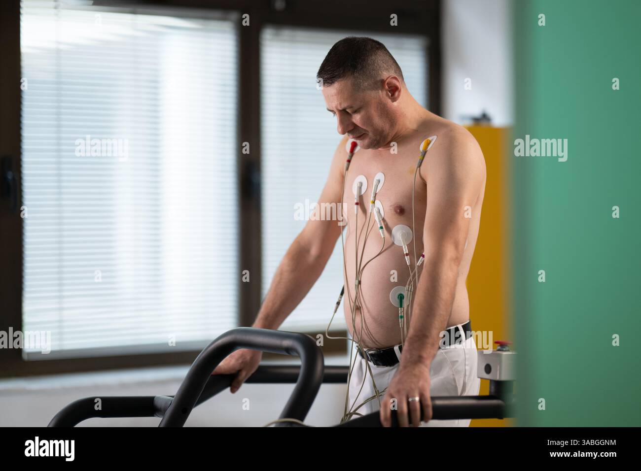 A Middle Aged Man Is Undergoing A Medical Stress Test On A Treadmill Connected To Ecg