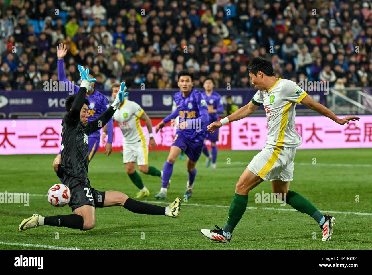 Tianjin. 2nd Apr, 2025. Li Lei (R) of Beijing Guoan shoots to score ...