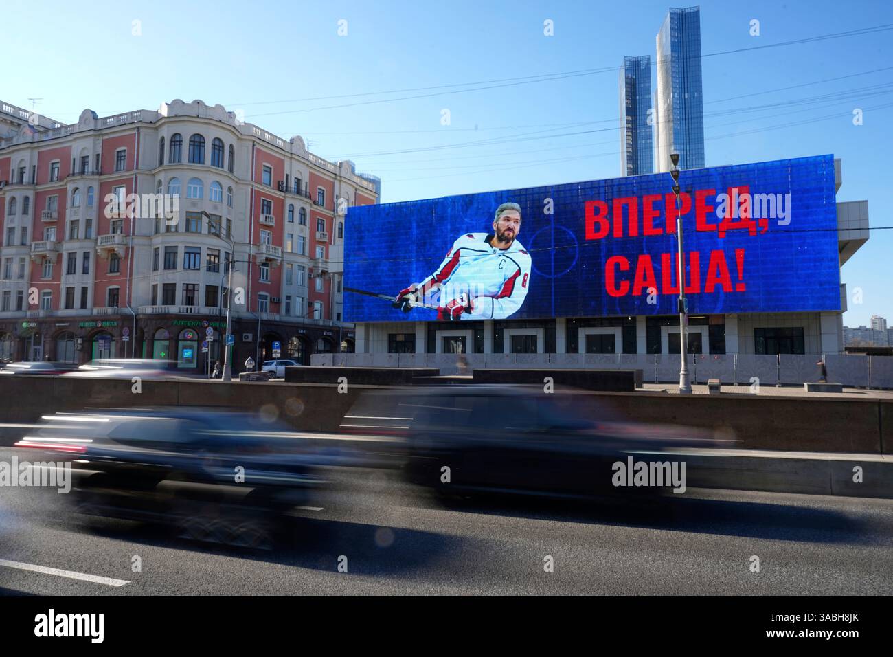 Cars drive past a screen depicting Washington Capitals' Alex Ovechkin ...