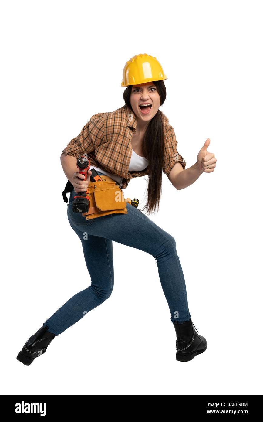 Excited female construction worker wearing a yellow hard hat and tool ...