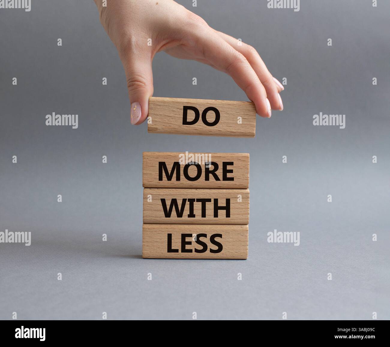 Do more with less symbol. Concept words Do more with less on wooden blocks. Beautiful grey ...