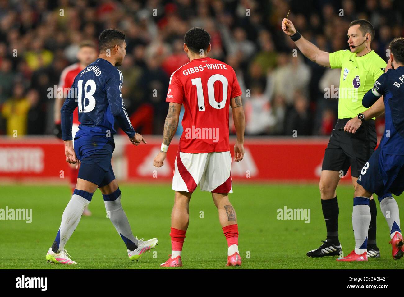 Referee, Jarred Gillett shows a yellow card to Casemiro of Manchester ...