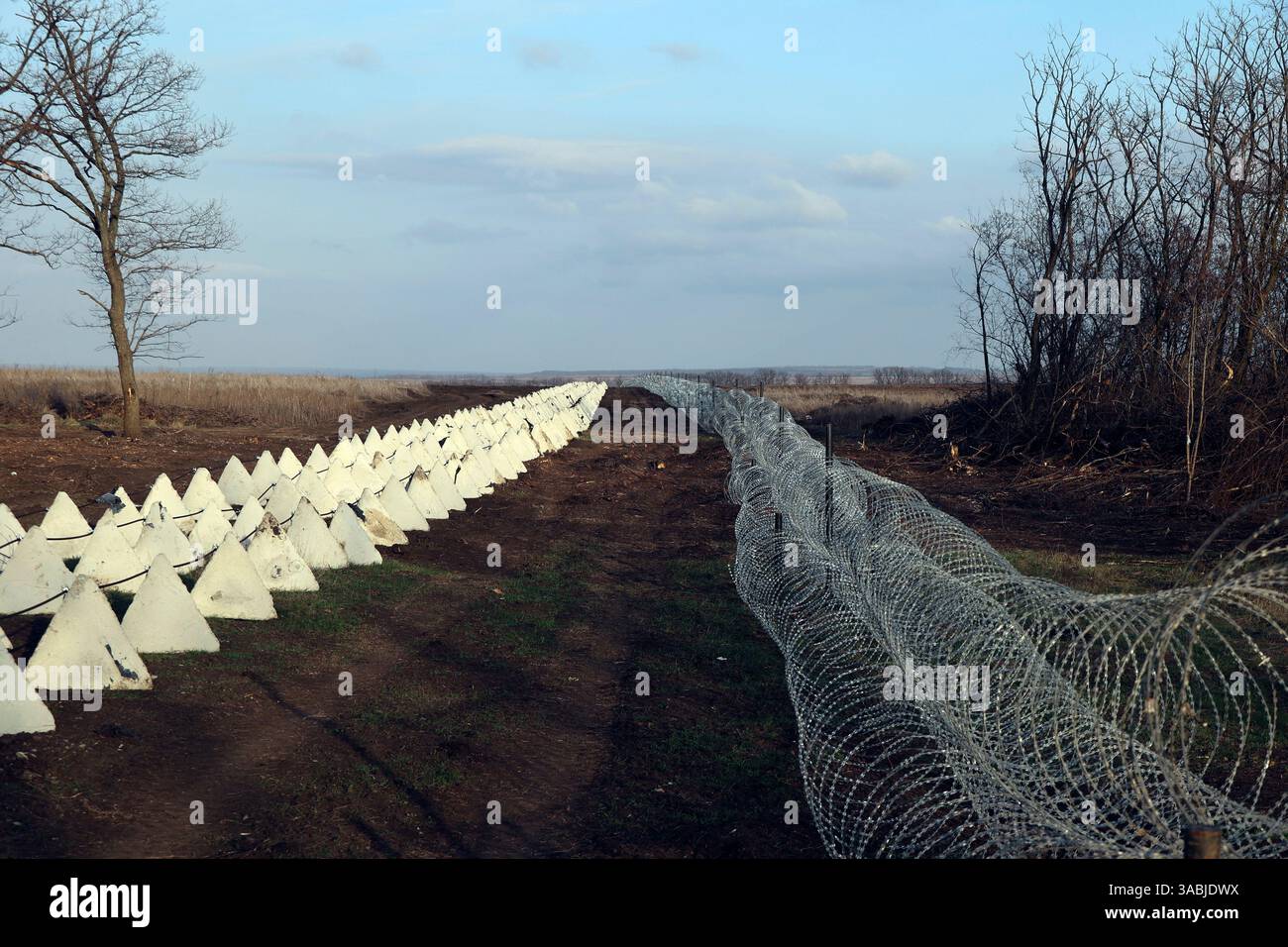 The lines of barbed wire and pyramidal anti-tank obstacles (dragon’s ...