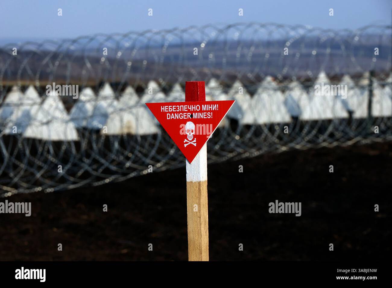The "Danger Mines!" sign is installed in front of the lines of barbed ...