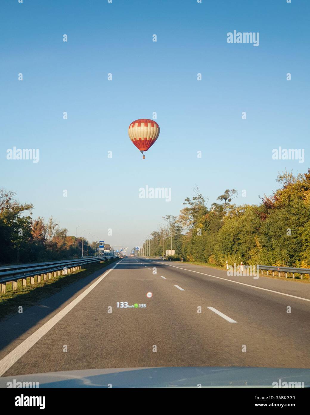 Point of view: driving on empty highway in left lane. Car with cruise ...