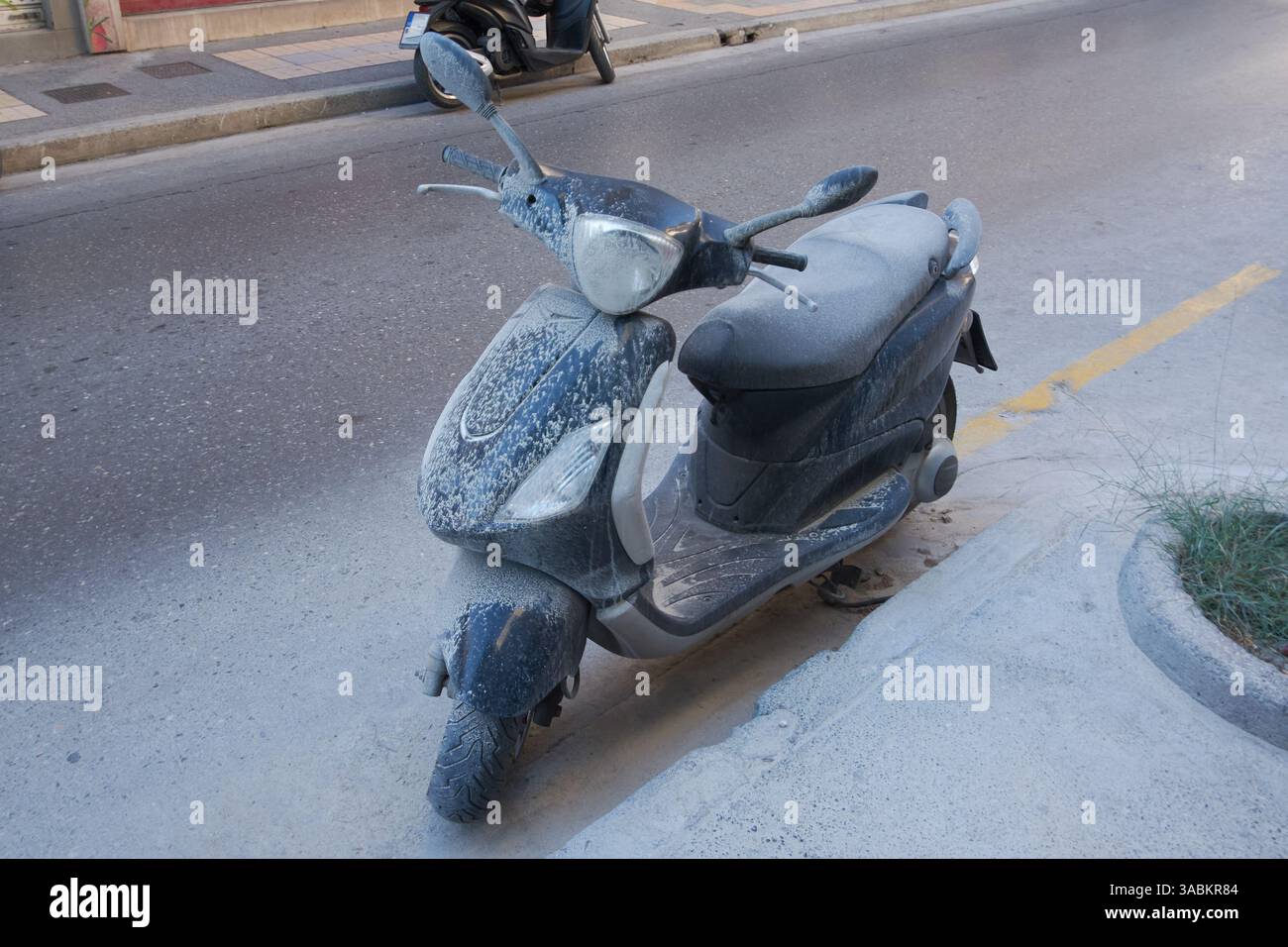 Dusty motorcycle parked on a city street with visible dirt and grime ...
