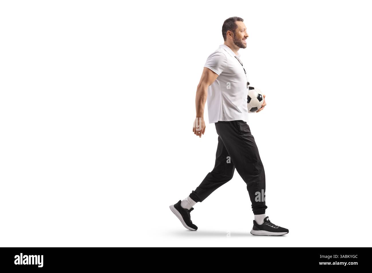Football coach walking and carrying a ball isolated on white background ...