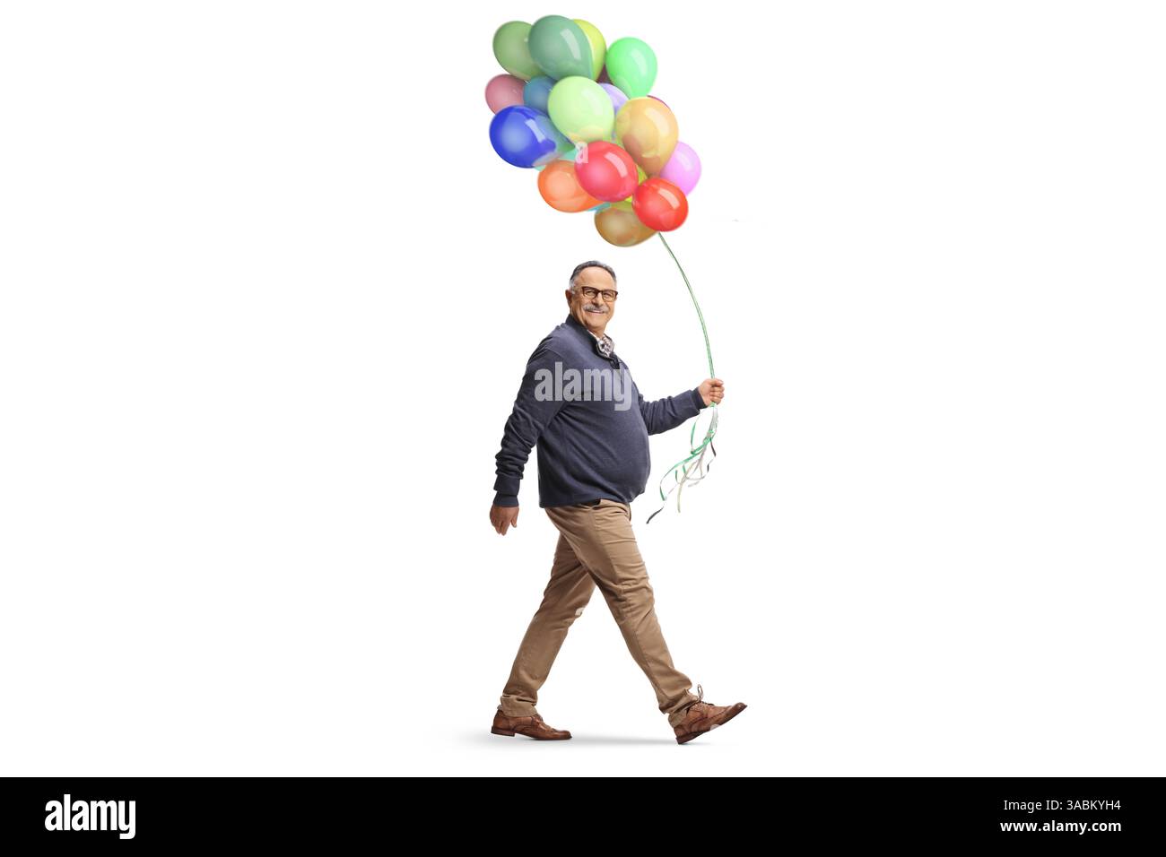 Mature man walking with a bunch of colorful balloons isolated on white ...