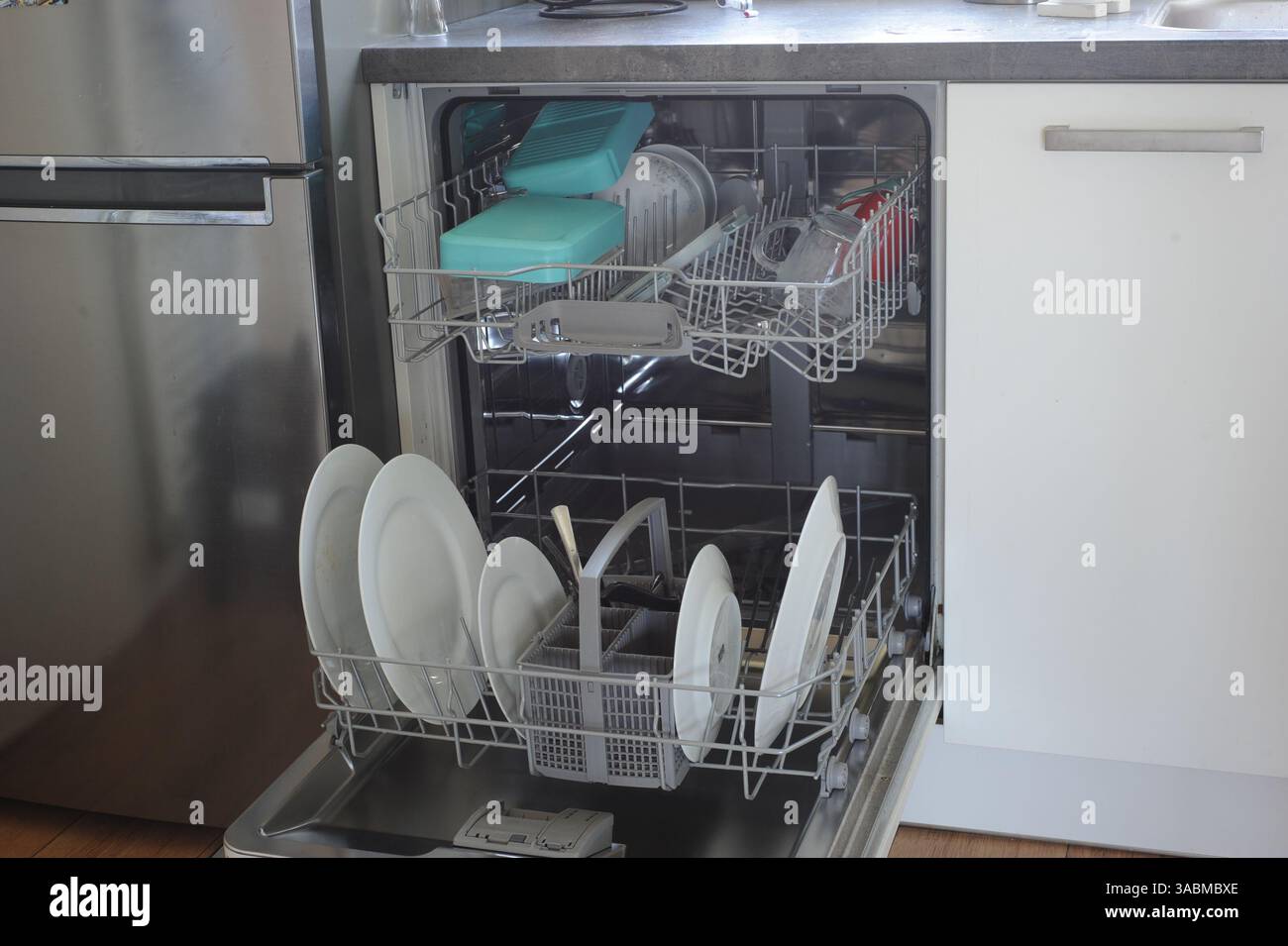 Modern kitchen with built-in open dishwasher with dishes Stock Photo ...