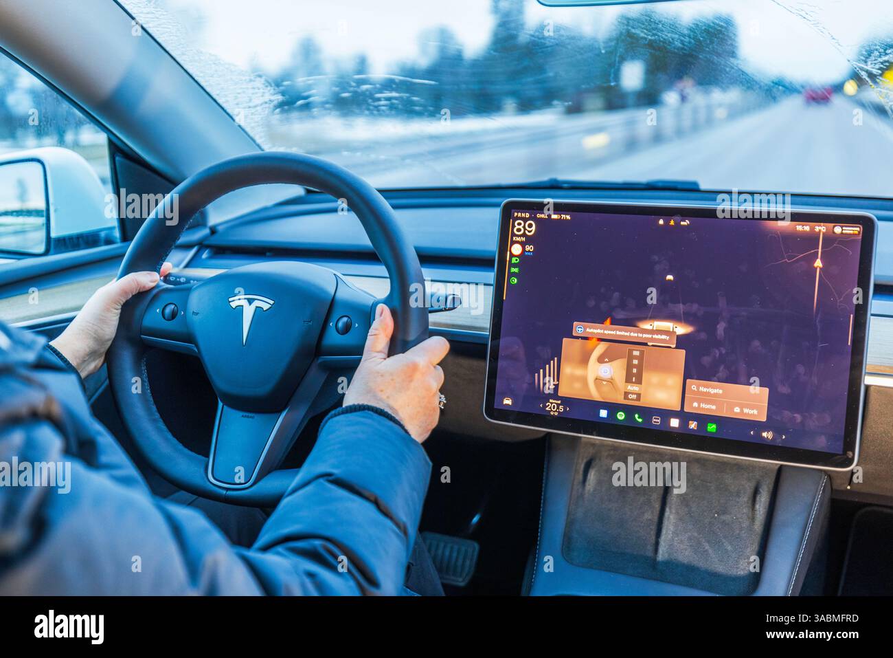 Woman driving Tesla Model Y on winter road using autopilot system with ...