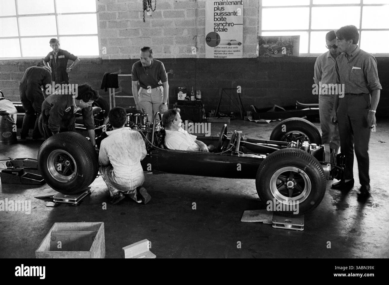 The Lotus mechanics, supervised by team owner Colin Chapman (GBR), work ...
