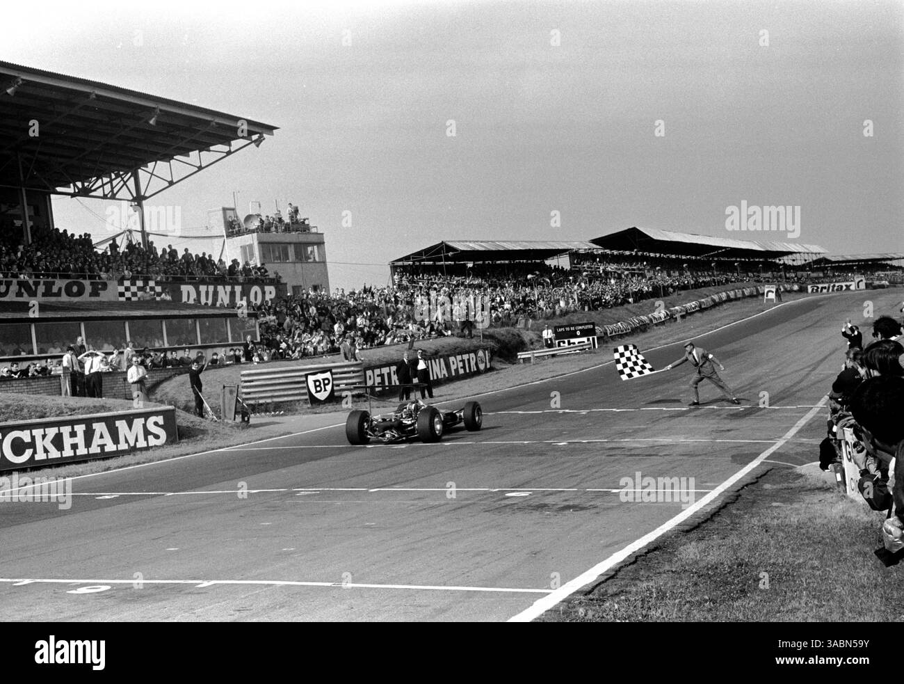 Race winner Jo Stiffert (SUI) Lotus 49B crosses the finish line ...