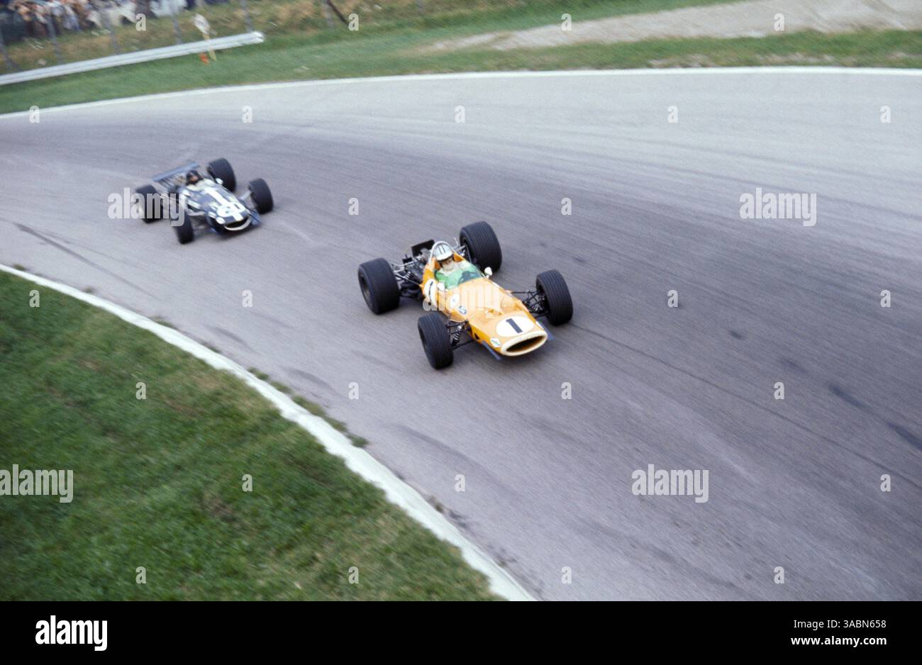 Race winner Denny Hulme (NZL) McLaren Cosworth M7A, leads Dan Gurney ...
