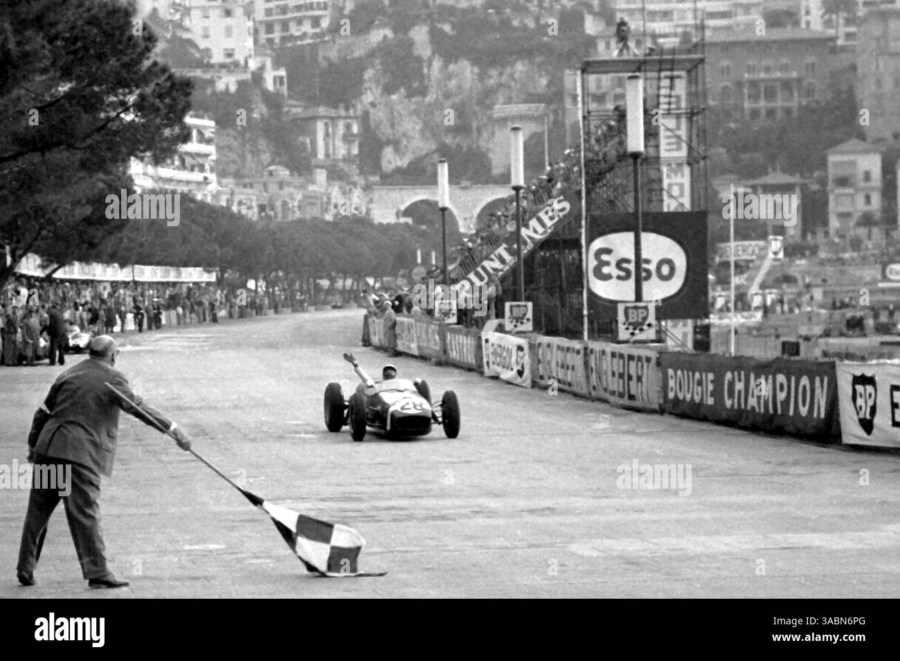 Race winner Stirling Moss (GBR) Lotus 18 crosses the finish line. This ...