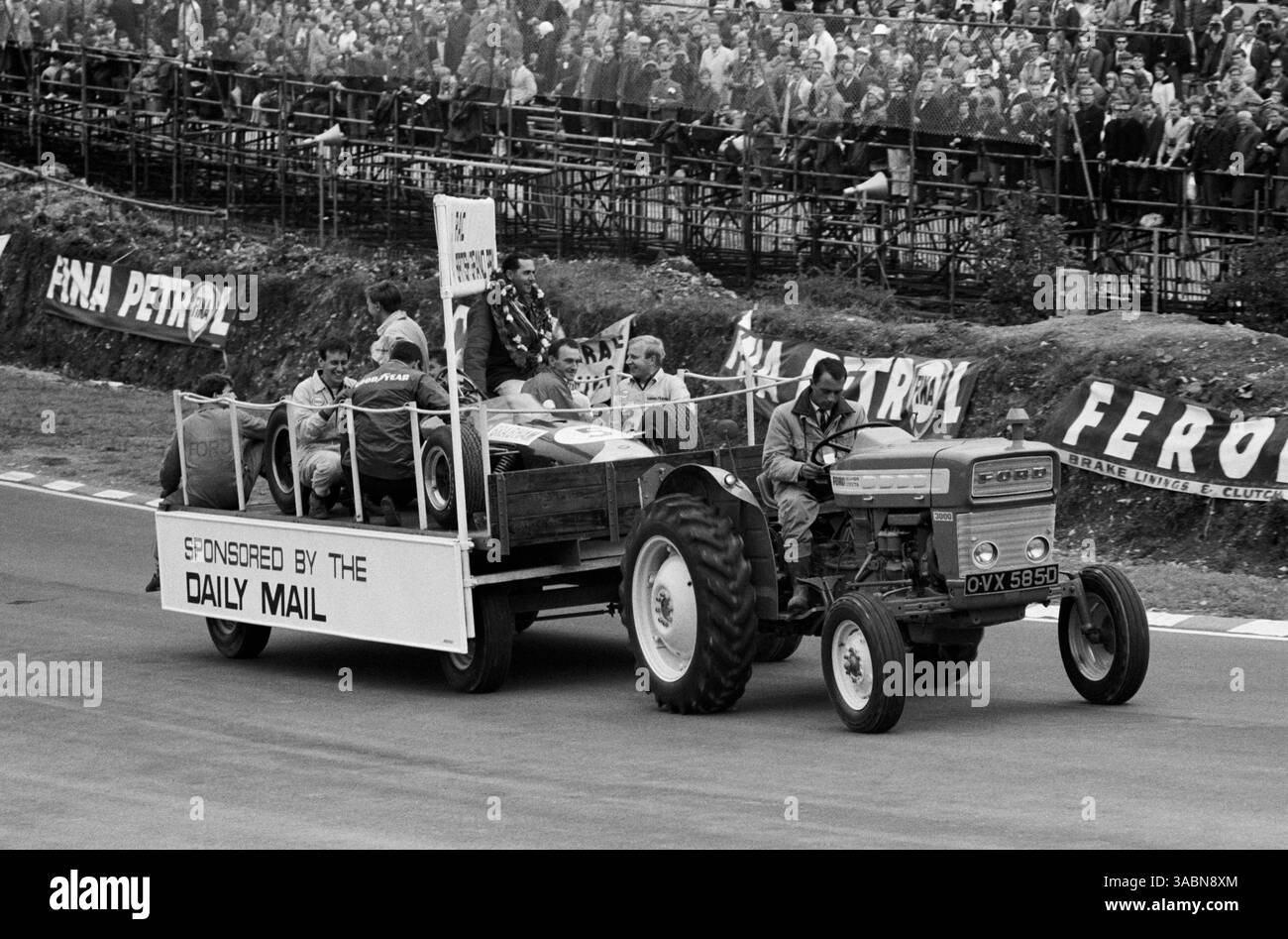 Race winner Jack Brabham (AUS) takes a lap of honour on a tractor ...