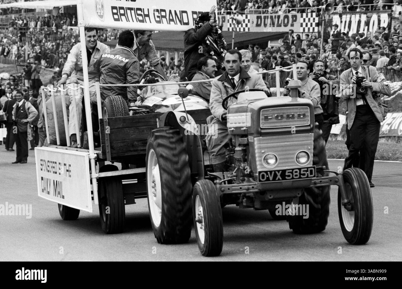 Race winner Jack Brabham (AUS) takes a lap of honour on a tractor ...