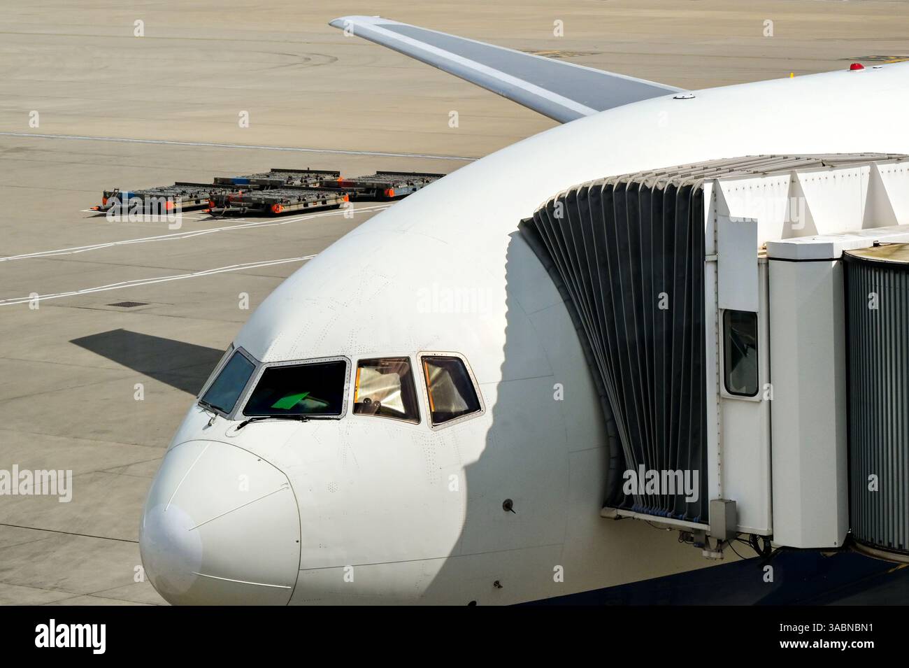 Nose of an unmarked large long-haul jet attached to a passenger ...