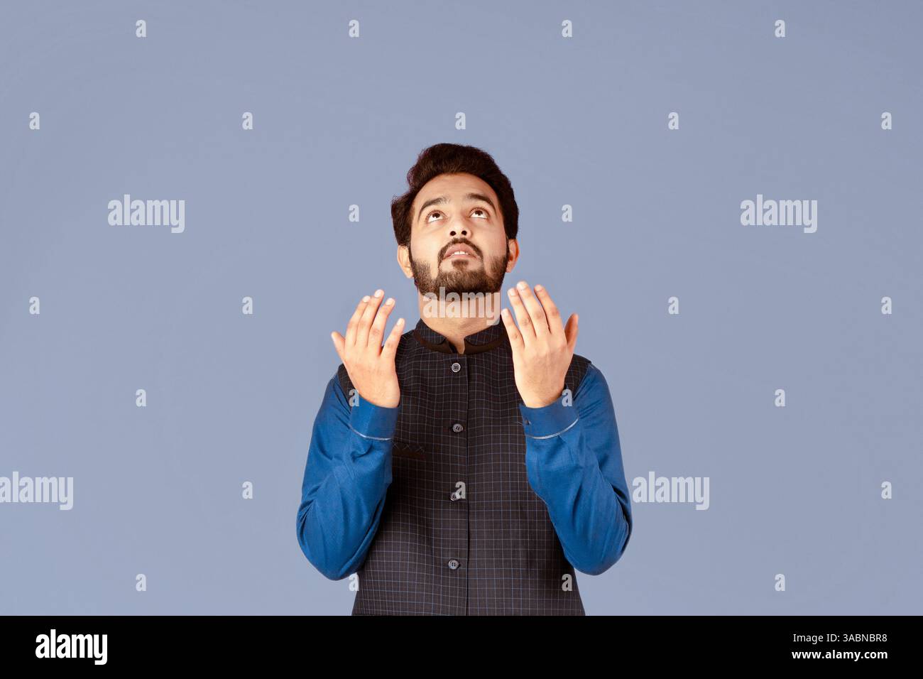 Religious Indian guy praying to God, asking for redemption on violet ...