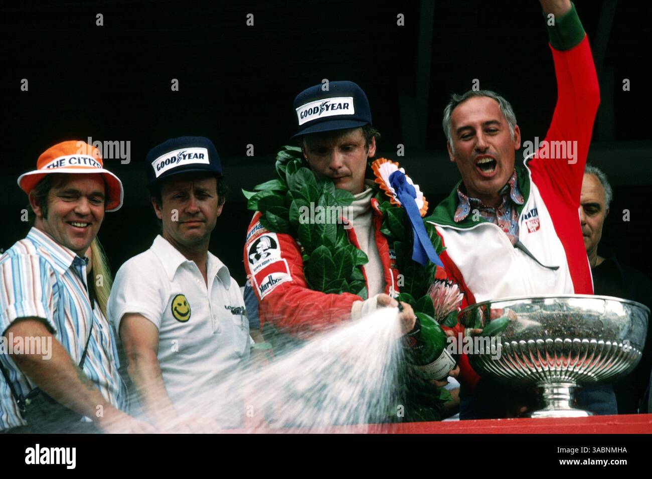Niki Lauda (AUT) (Centre) celebrates on the podium his first victory ...