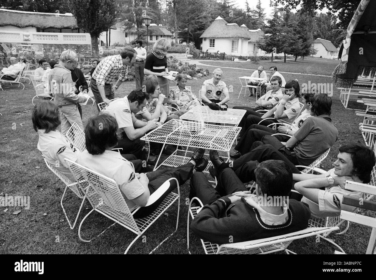 Colin Chapman (GBR) Lotus Team Owner (Far end) holds a Lotus team ...