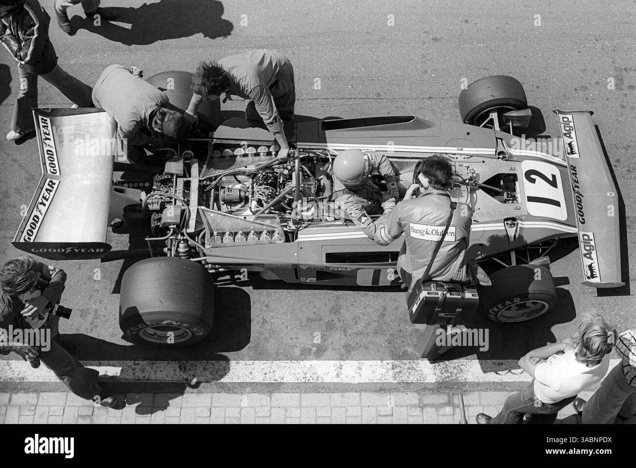 Race winner Niki Lauda (AUT) sits in the pits as mechanics work on his Ferrari 312B3 during ...