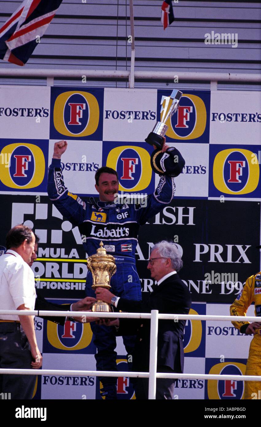 Race winner Nigel Mansell (GBR) Williams celebrates on the podium ...