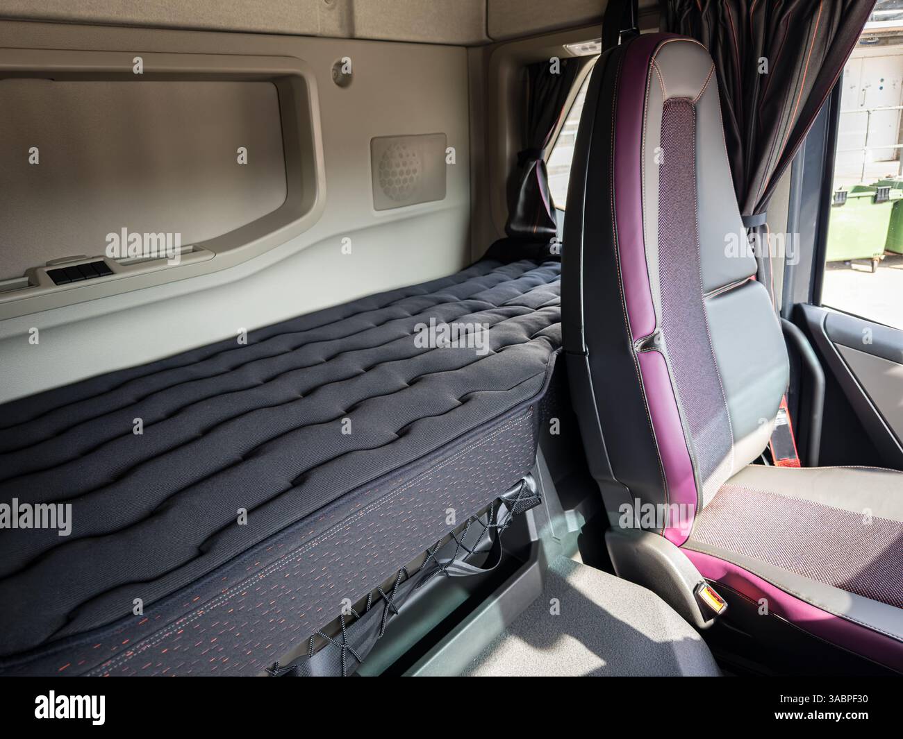 A comfortable sleeper bed inside a truck cabin, designed to provide ...