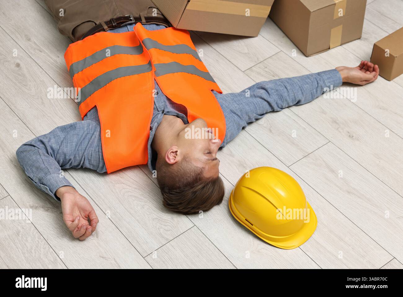 Accident at work. Unconscious man lying on floor in warehouse Stock ...
