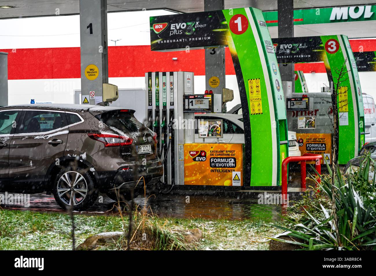 Exterior of an MOL gas station. Gasoline pumps and cars refueling in a ...