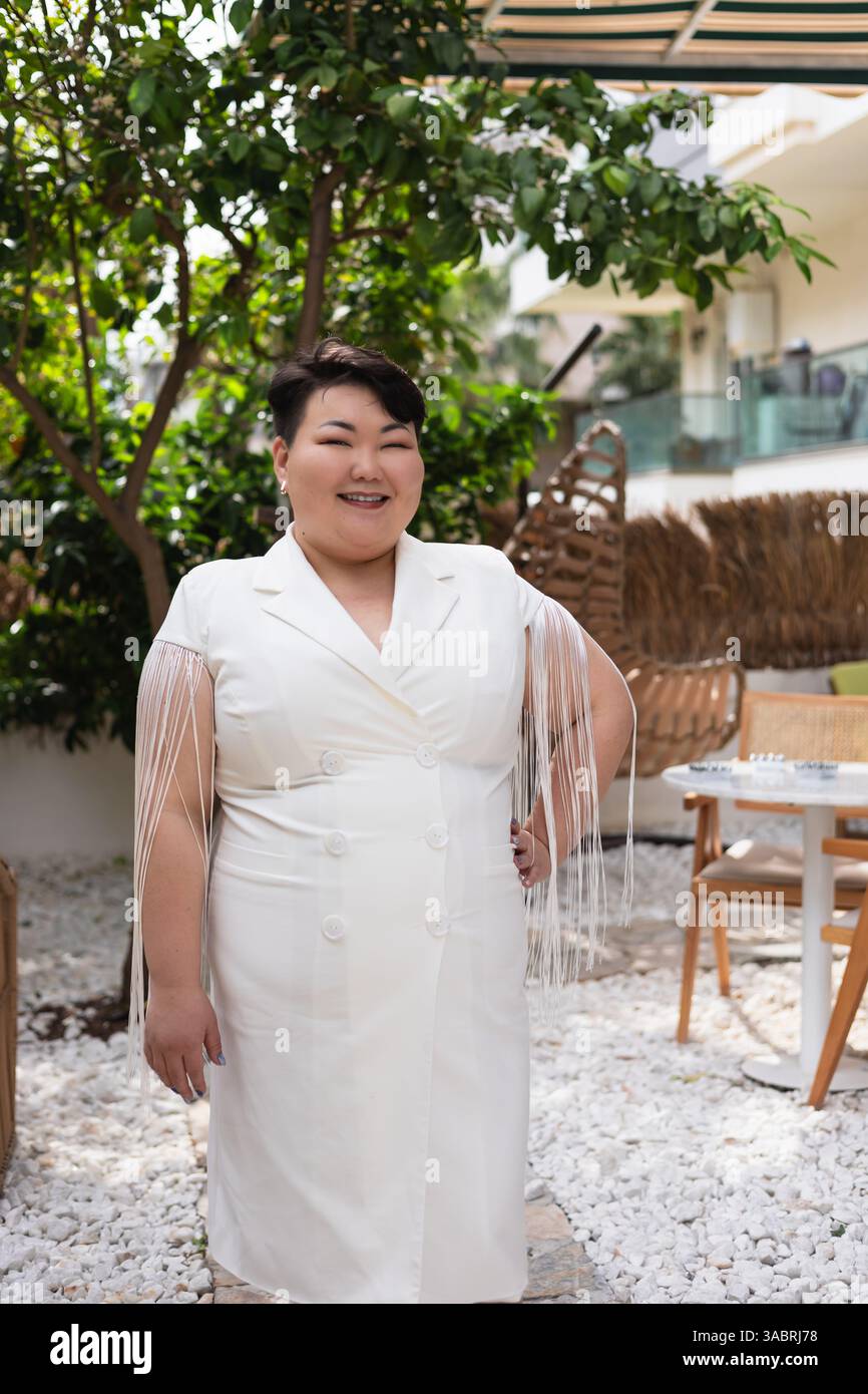 Portrait of plus size woman wearing stylish white dress with fringe ...