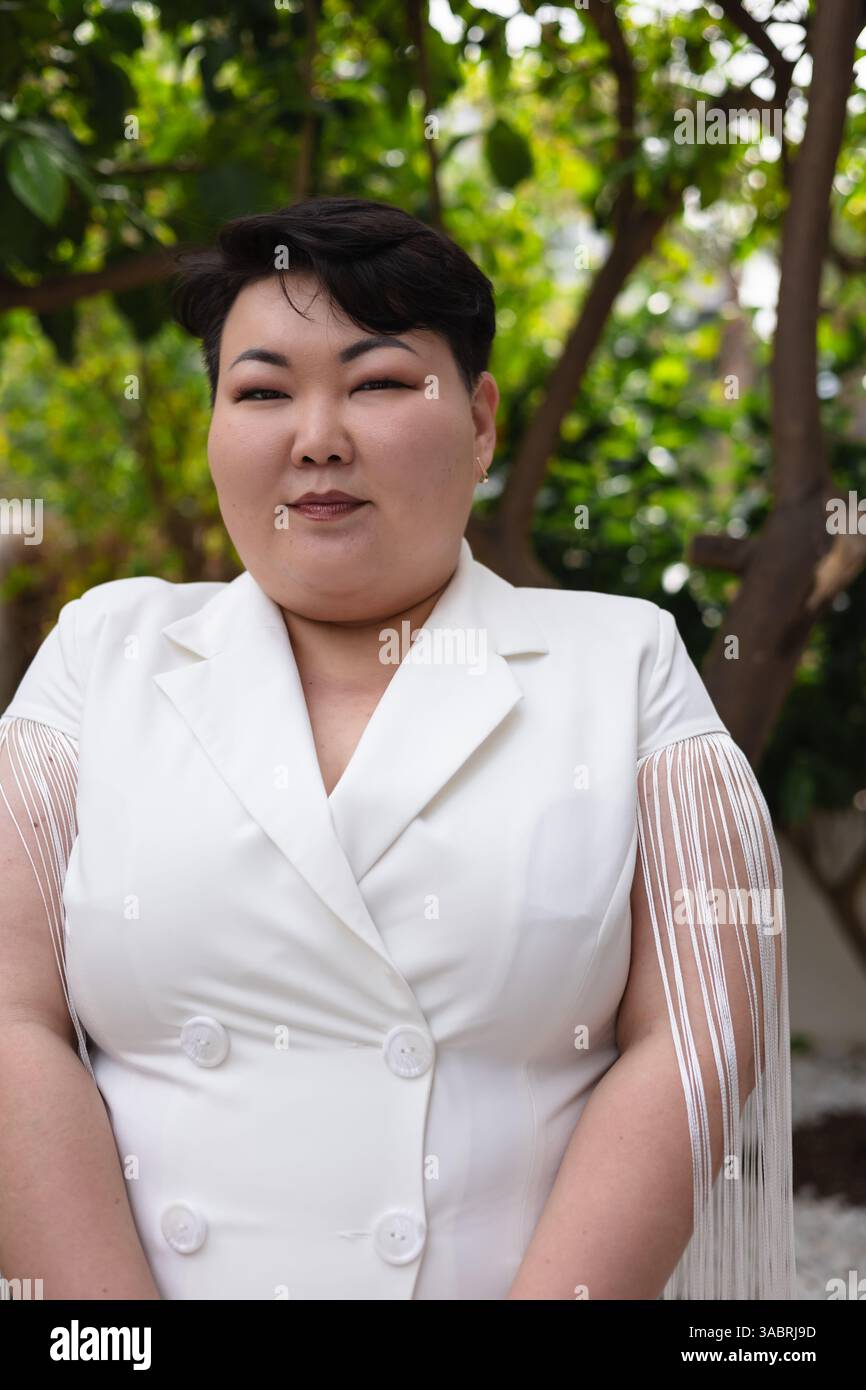 Portrait of plus size woman wearing stylish white dress with fringe ...
