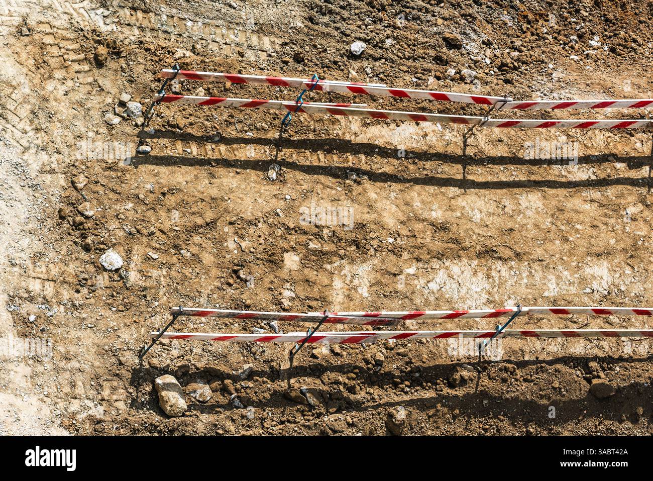 Construction site preparation with safety barriers installed on dirt ...