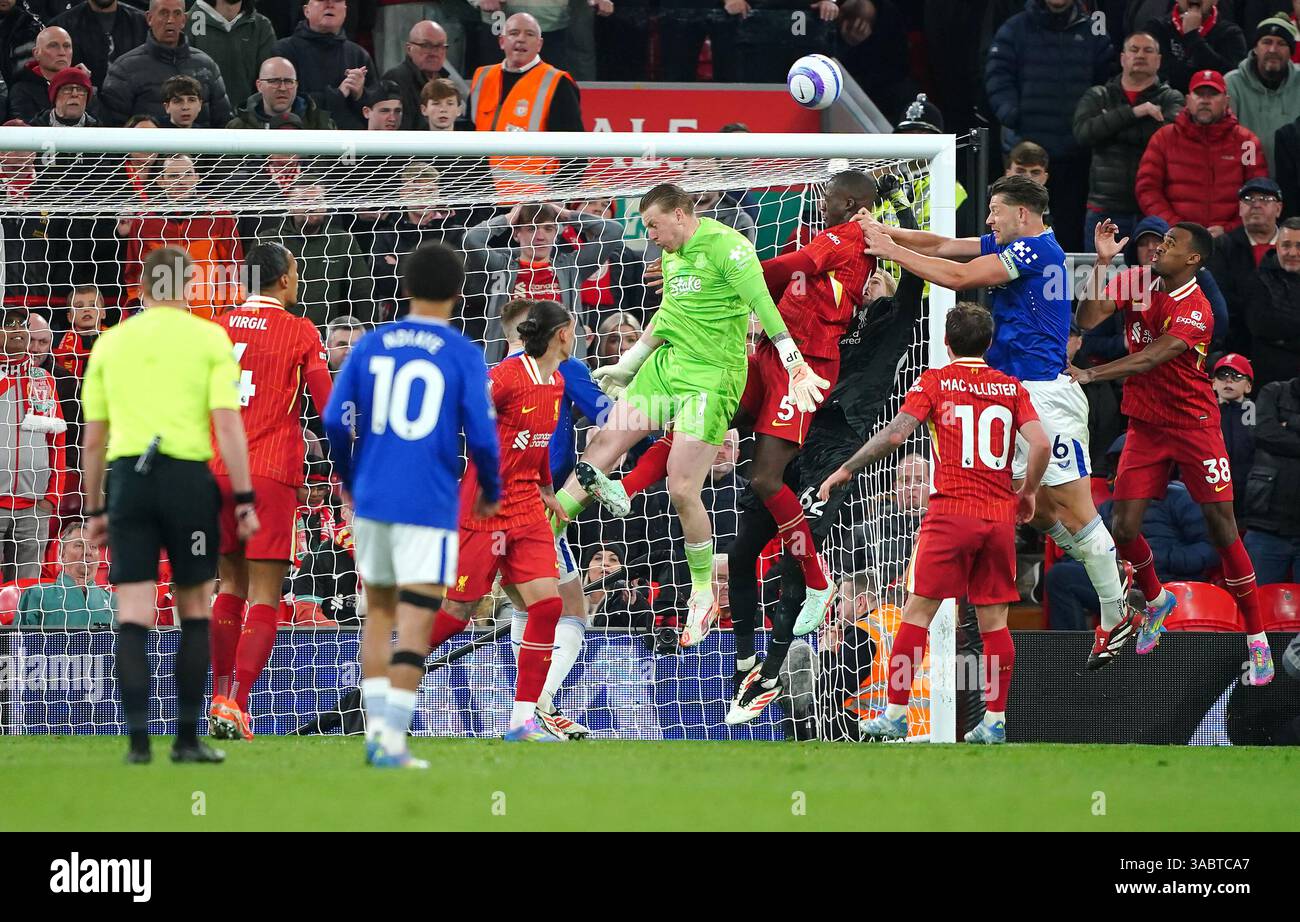 Everton goalkeeper Jordan Pickford (centre) attempts to head the ball ...