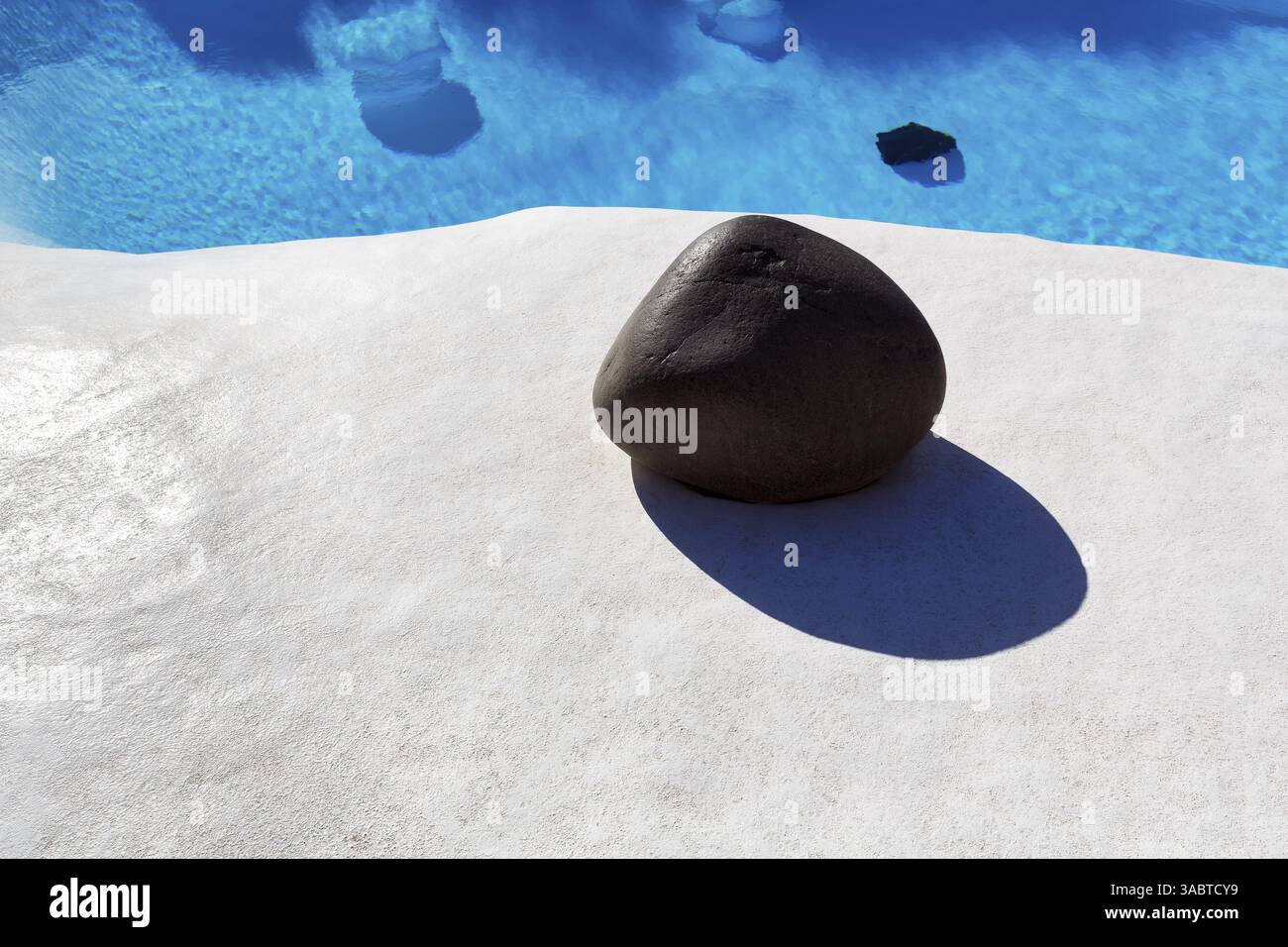 Black lava stone, decoration at the swimming pool, turquoise blue water ...