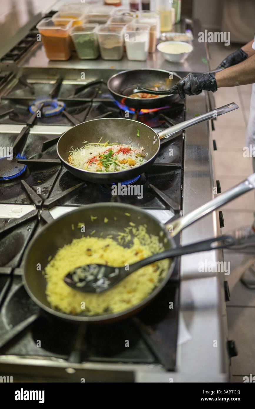 Chefs cooking traditional Indian dishes like biryani and curry, using ...