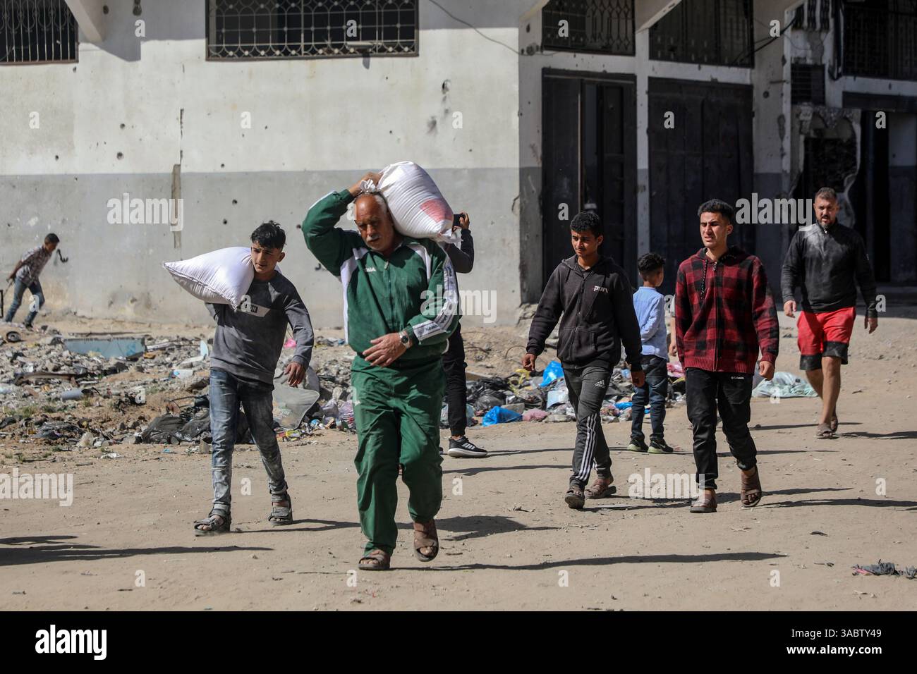 Gaza. 2nd Apr, 2025. Palestinians carry bags of flour in the al-Tuffah ...