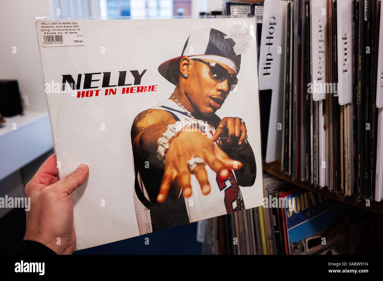 Lviv, Ukraine - April 01, 2025: A person holds a vinyl record of Nelly album Hot in Herre (2002 ...
