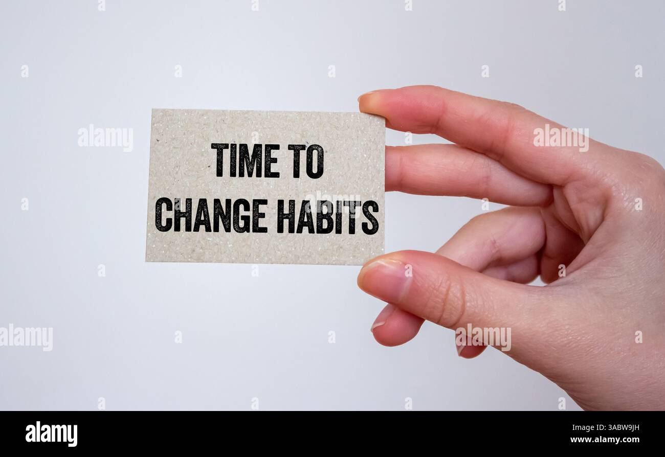 Time to change habits message written on a card in hand. Conceptual ...