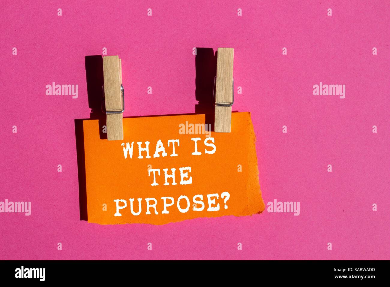 What is the purpose message written on ripped torn orange paper on pink ...