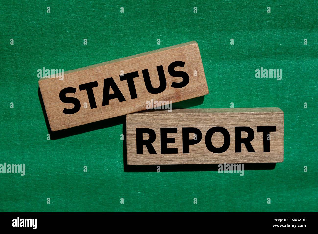 Status report message written on wooden blocks on green background ...