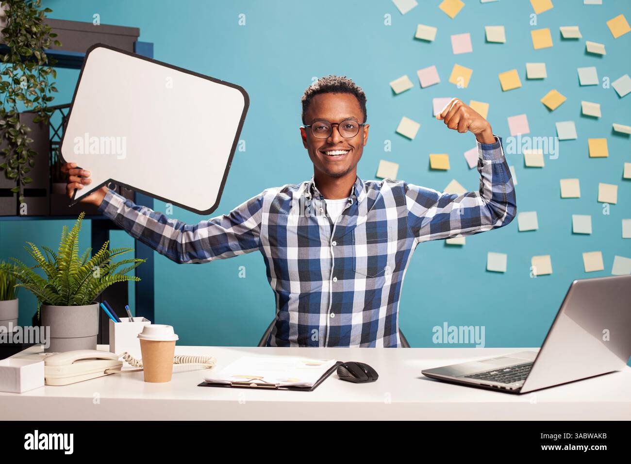 Happy project manager holding a blank speech bubble and flexing his arm ...