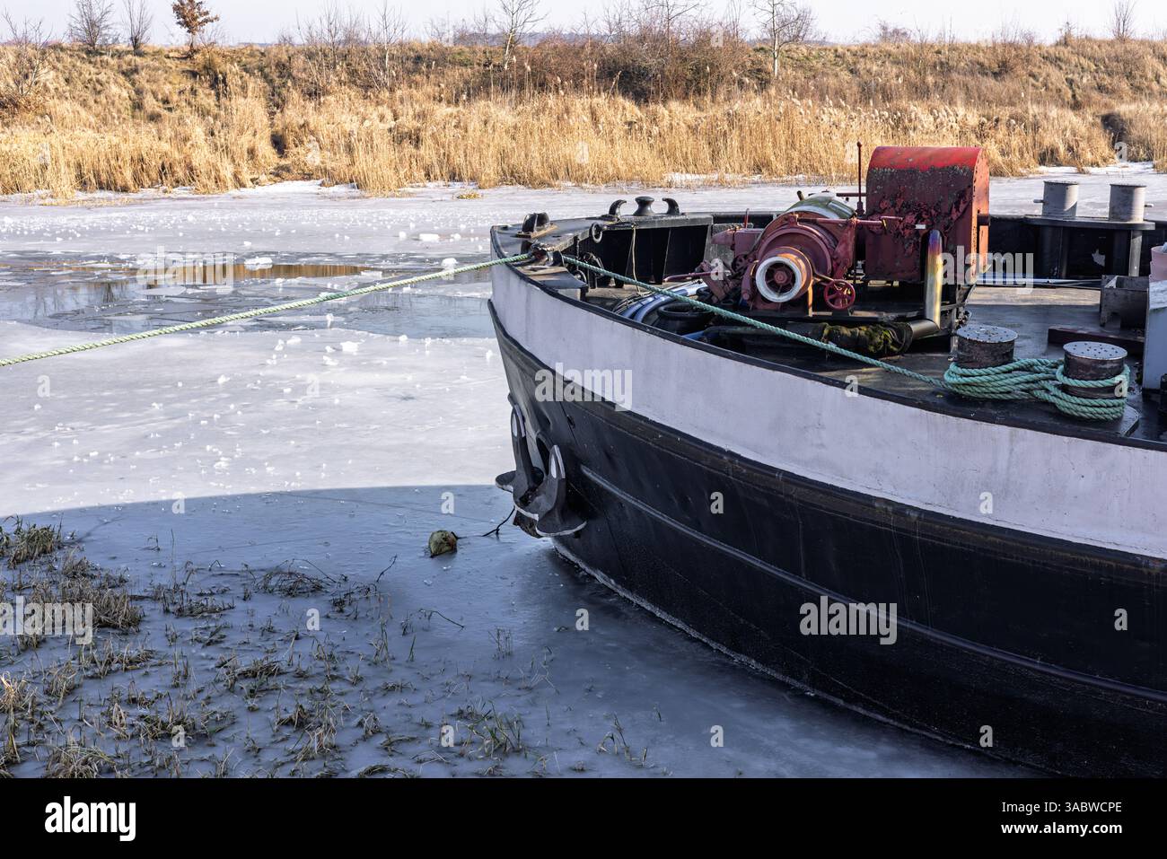 The bow of a barge on an ice-bound river. Rigging on the deck of the ...