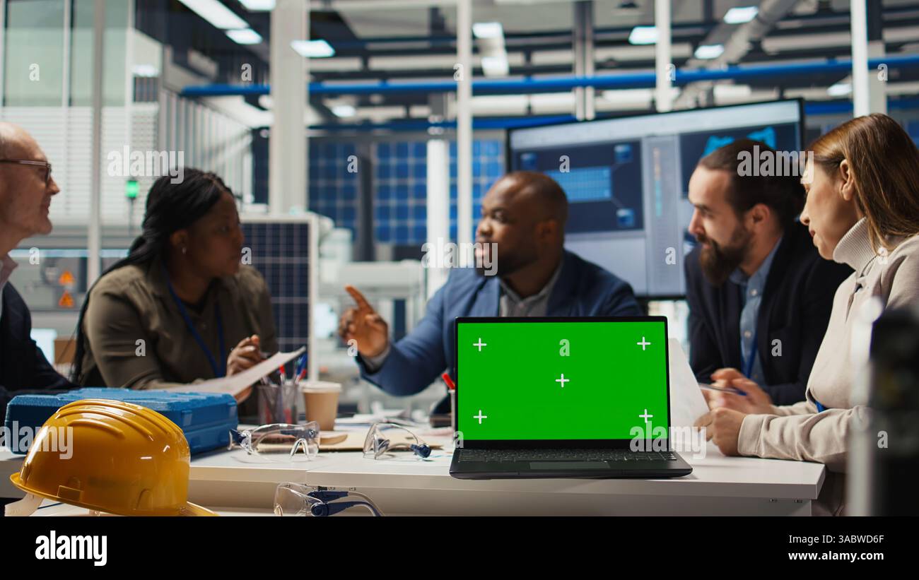 Factory engineers using green screen laptop to refine designs for ...