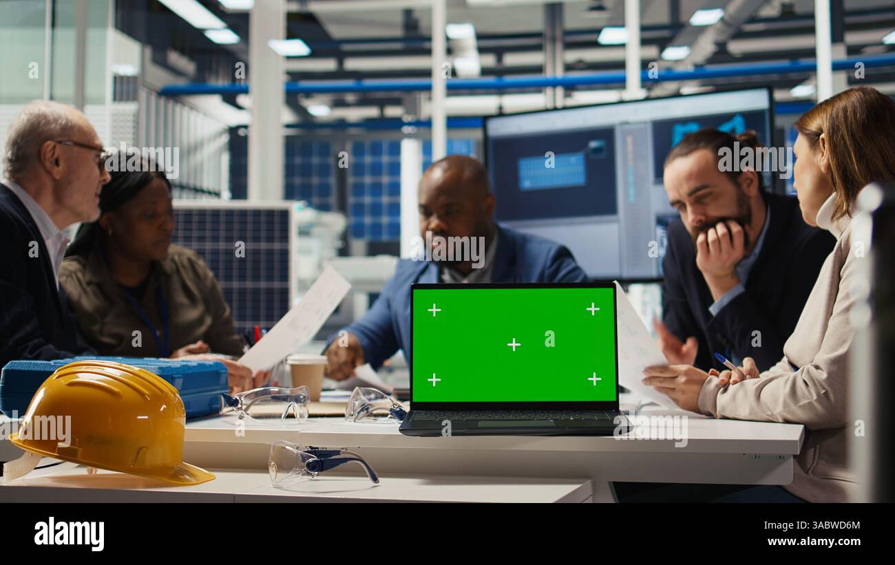 Factory engineers study schematics, refining production layouts using ...