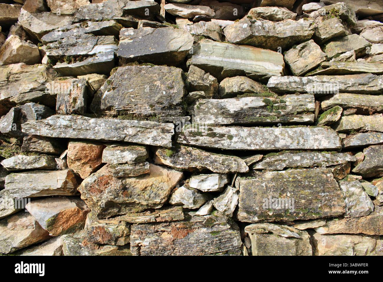 Rustic dry stone wall with flat, horizontal stones and moss. Natural ...