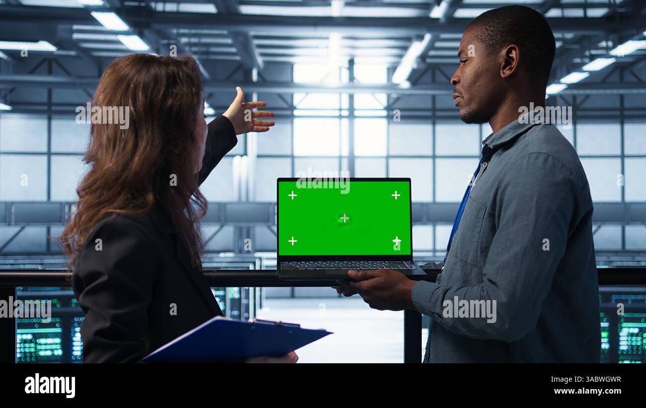 Engineering team in data center using green screen laptop, implementing predictive analytics ...