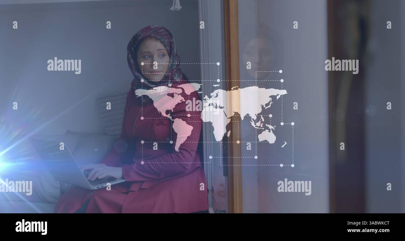 Image of world map over asian woman in hijab sitting and using laptop ...