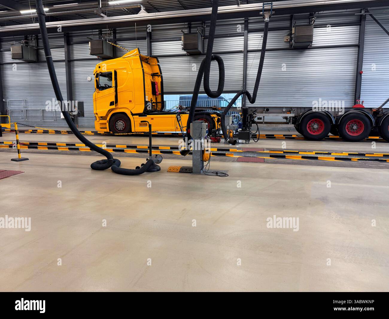 Yellow truck undergoing procedure of vehicle inspection at station ...