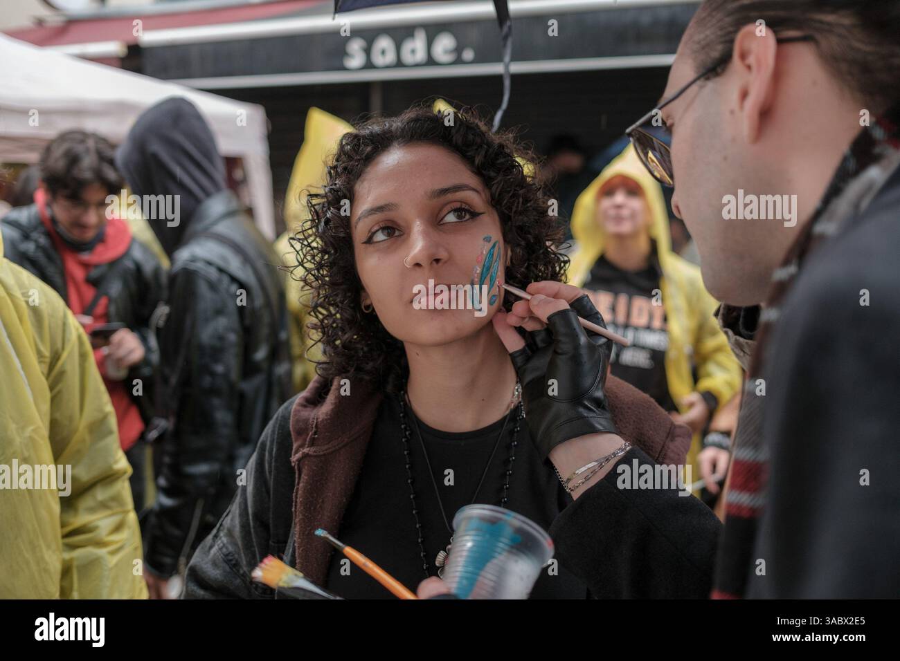 Izmir, Turkey. 02nd Apr, 2025. A woman paints her face at a swap market ...