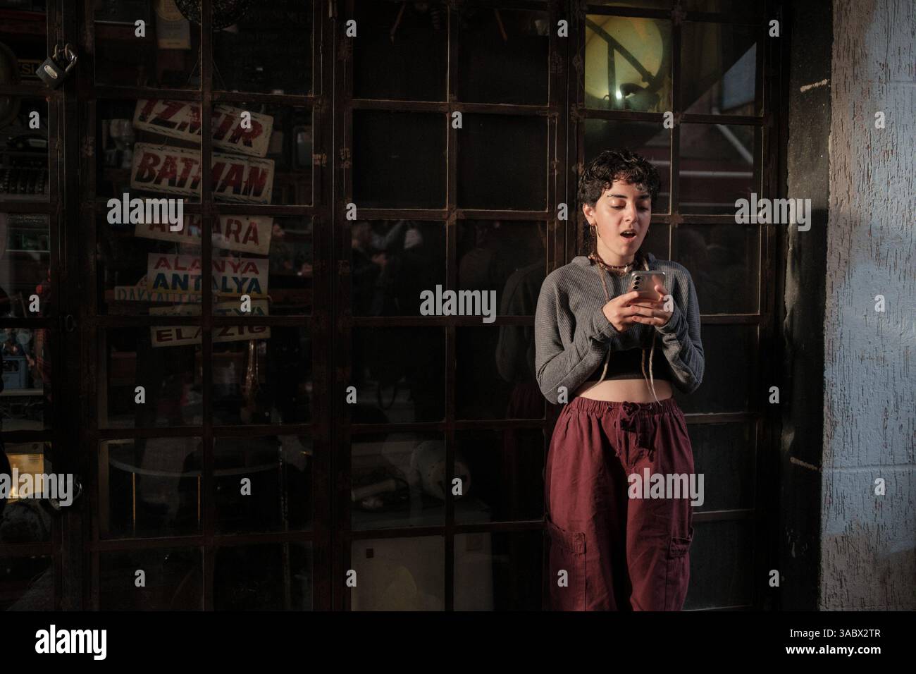 A woman looks at her phone in front of a shop closed due to the boycott ...